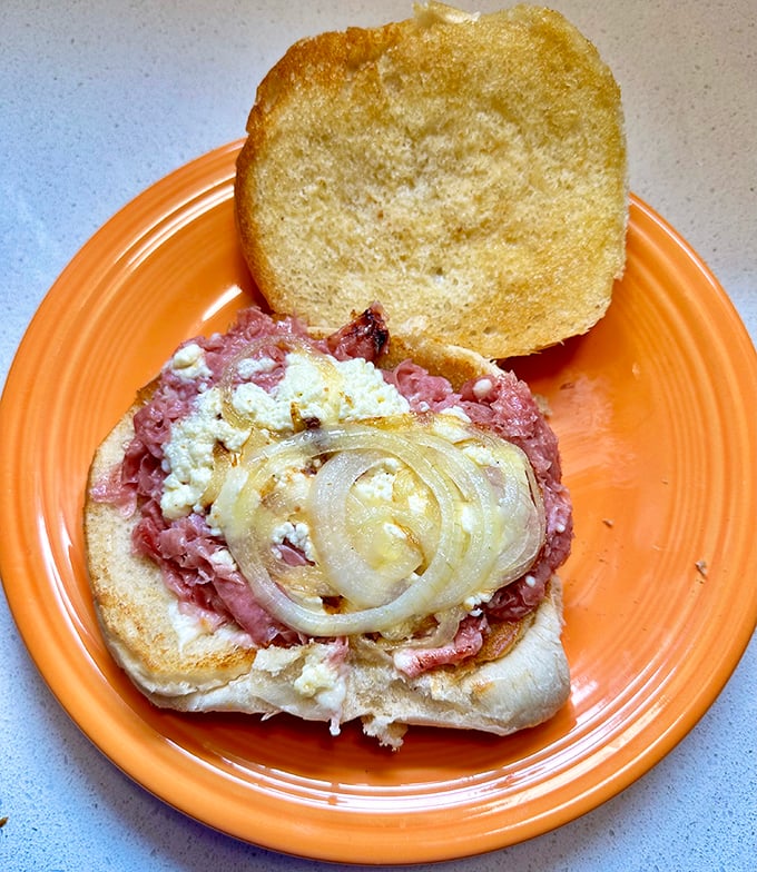 The chipped ham sandwich in its natural habitat – thinly shaved pink perfection topped with melted cheese and sweet onions on a toasted bun.