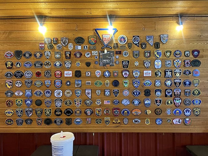 A wall of badges tells the story of pilgrims from fire departments and police stations nationwide who've made the journey for legendary BBQ.