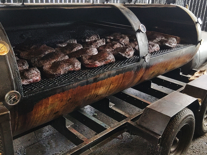 The offset smoker—barbecue's iron throne—where patience transforms tough cuts into tender treasures through the ancient alchemy of fire and time.