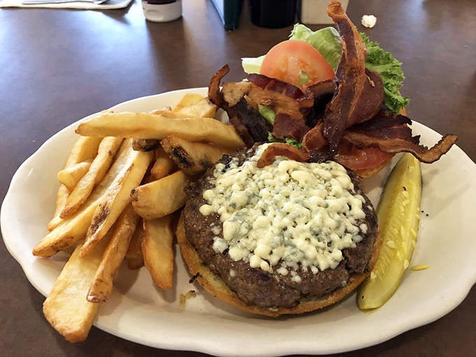 Burger architecture at its finest. Blue cheese melting into a perfectly cooked patty with bacon standing guard—this is how comfort food dresses for a night out.