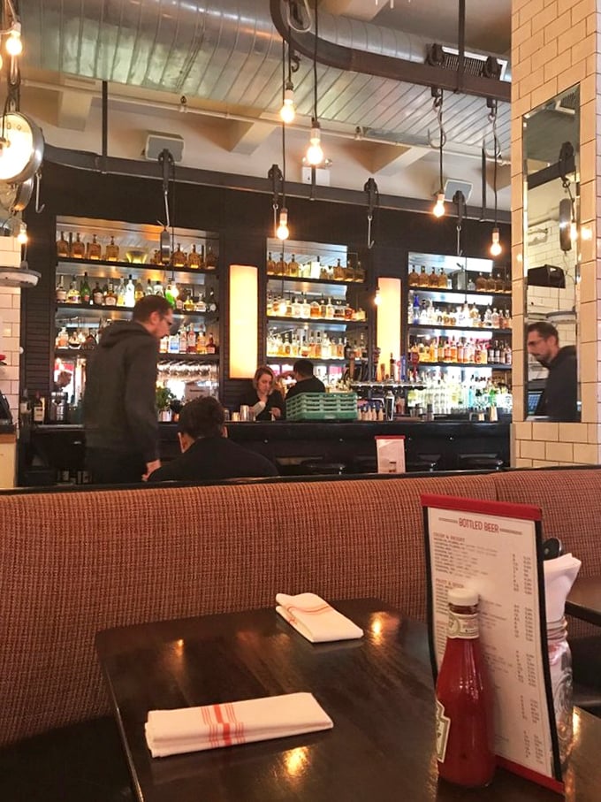 The bar gleams with infinite possibilities while patrons contemplate their next liquid adventure. Edison bulbs add that essential urban glow.