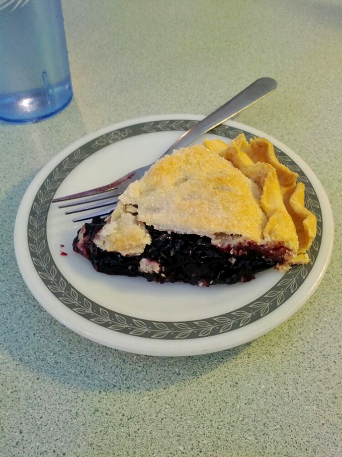 A slice of black raspberry pie that makes you wonder if fruit was put on earth specifically for this divine purpose.