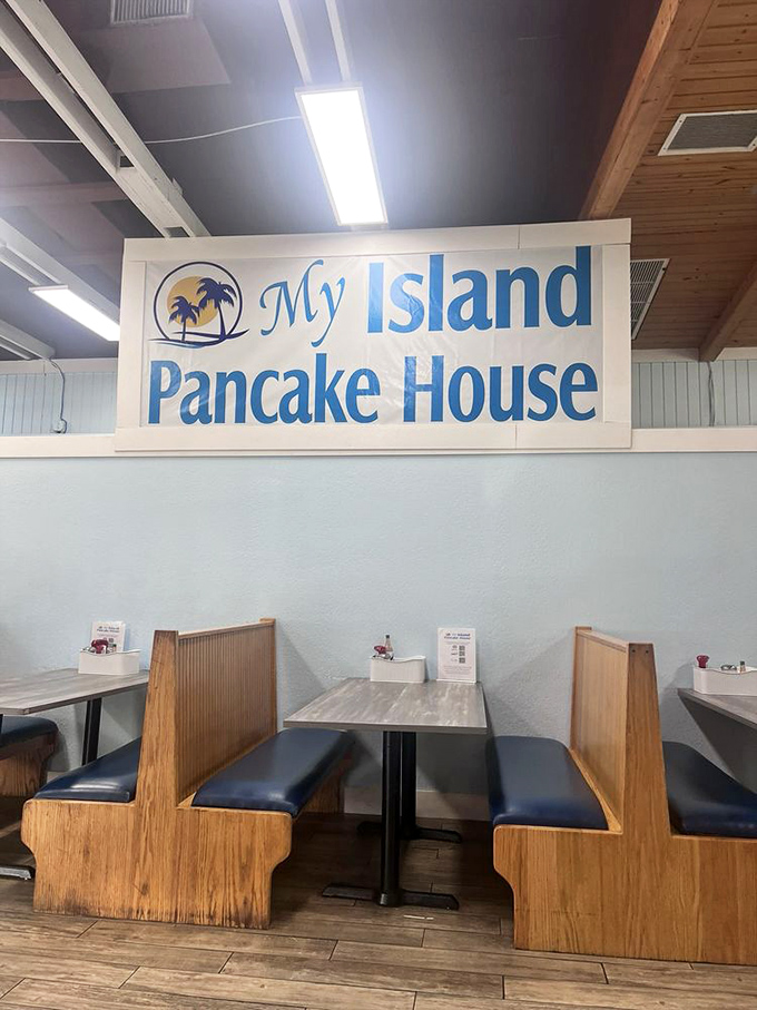 Classic diner booth seating under the watchful gaze of the restaurant's cheerful sign—where countless breakfast dreams have come true.