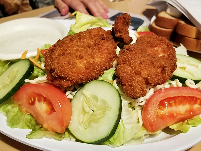 Crispy chicken tenders atop fresh vegetables—the culinary equivalent of business on top, party on the bottom.