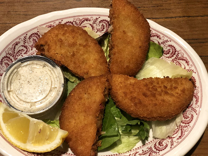 These golden-fried crab cakes aren't just appetizers—they're discs of seafood joy that make you question why you don't live closer to Schwarz's.