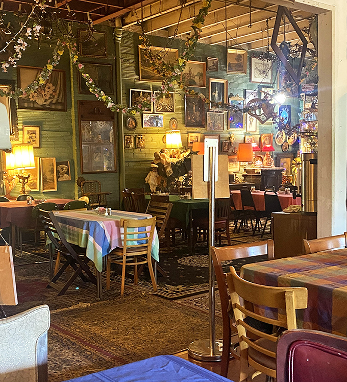 Art climbs the walls like ambitious ivy, creating a dining room that feels more like a bohemian gallery where food is the main exhibit.