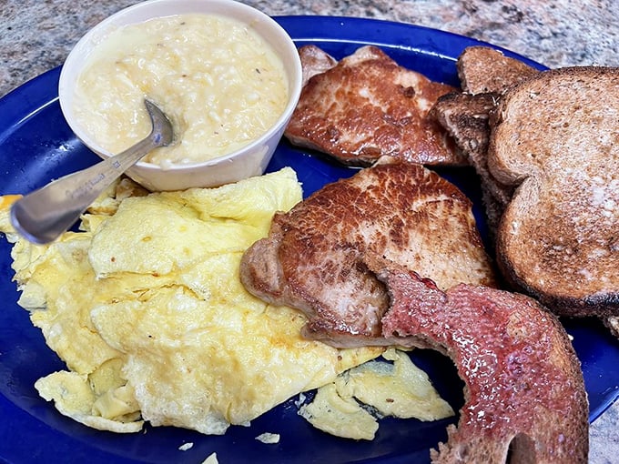 A breakfast plate that means business – eggs, pork chops, and potatoes that remind you why morning meals deserve our undivided attention.