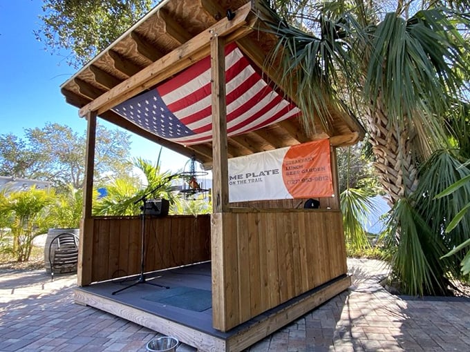 A stage for live music under an American flag—because pancakes taste better with patriotism and a soundtrack. The wooden structure has rustic charm to spare.