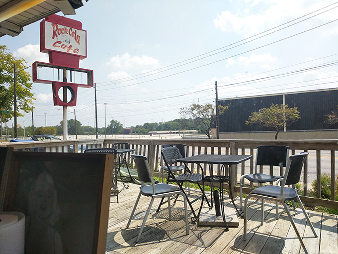 The outdoor seating area offers fresh air and a front-row seat to watch the world go by, all while the iconic sign stands guard.
