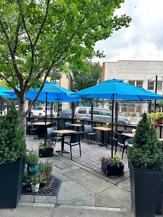 The patio where summer evenings stretch into memory. Blue umbrellas echo the ocean theme while Kansas breezes provide the soundtrack.