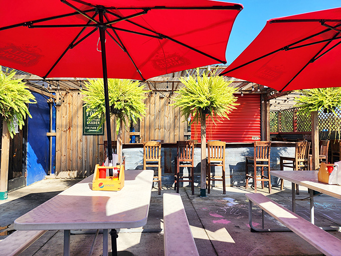 Outdoor seating bathed in sunshine and topped with vibrant red umbrellas—fish and chips taste even better with a side of fresh air.