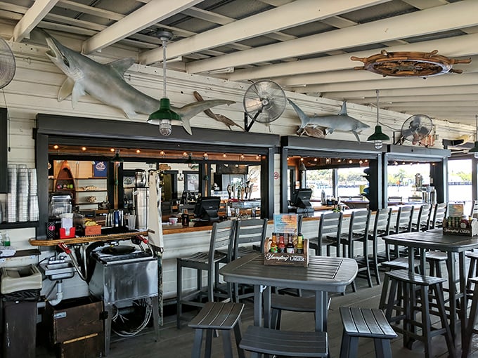Dining under shark sentinels. The open-air seating area, complete with overhead marine life, offers the perfect blend of indoor comfort and outdoor ambiance.