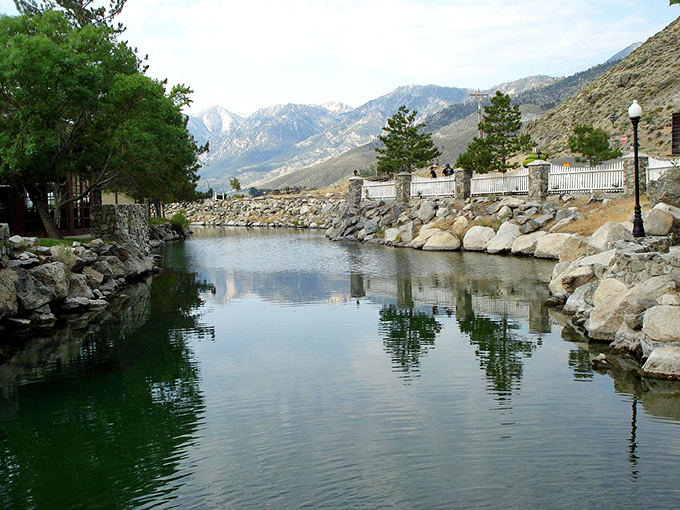 The peaceful pond reflects the majestic mountains beyond – nature's version of a double feature that never gets old.