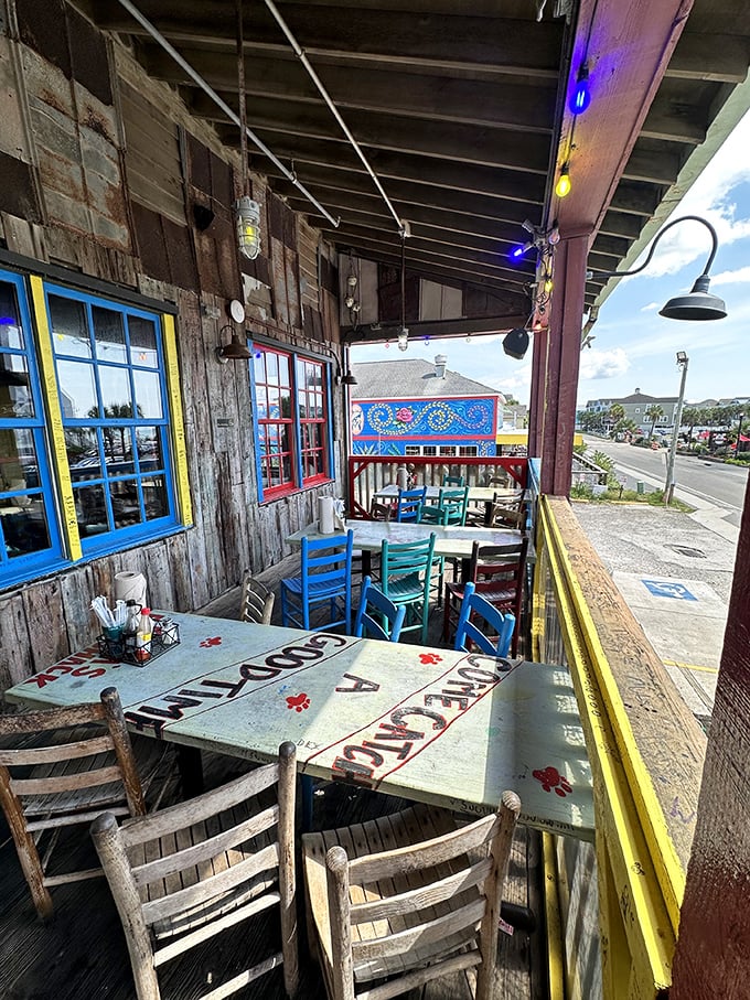 Outdoor seating with weathered tables and colorful chairs offers ocean breezes with your seafood feast—nature's perfect dining companion.