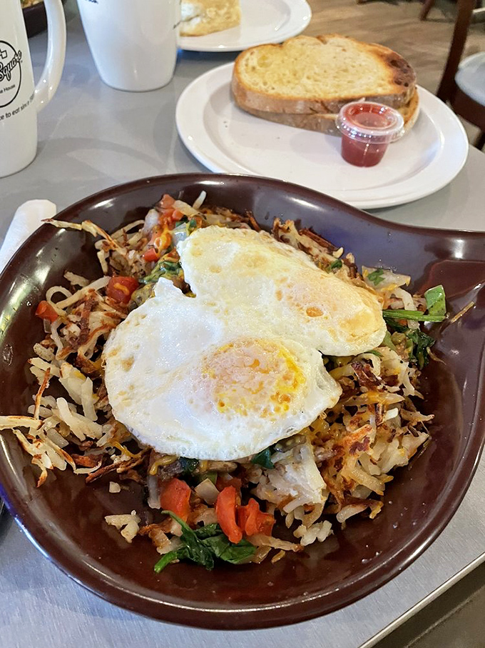 A skillet that tells a colorful story—crispy potatoes, vibrant vegetables, and those sunny-side-up eggs acting like the morning stars of this breakfast galaxy.
