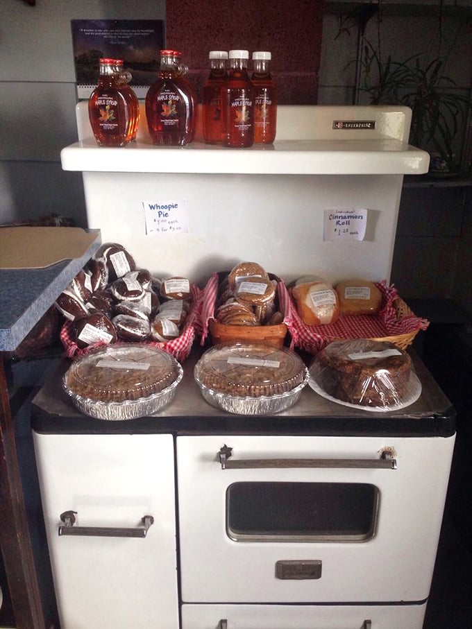 An antique white cookstove displaying its treasures—whoopie pies and pastries arranged like precious artifacts in a museum of deliciousness.