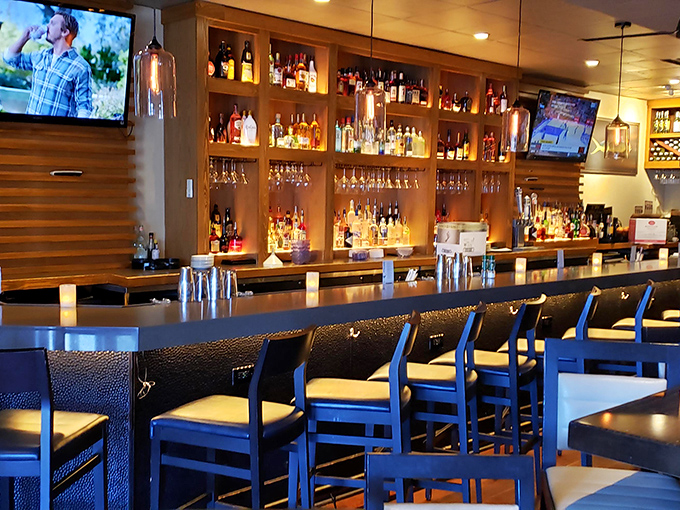 A bar that beckons with amber-lit bottles and comfortable seating – where "just one drink" often turns into dinner and dessert.