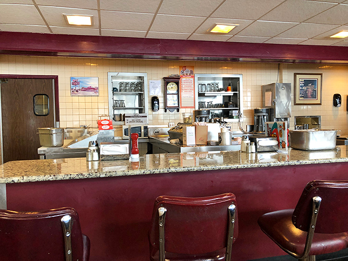 The counter seats—where solo diners become regulars, and the staff eventually knows your order before you've even settled onto that burgundy stool.