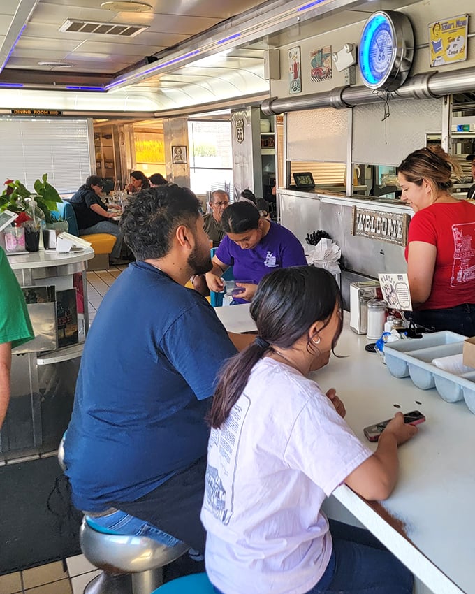 The counter seating—where strangers become temporary neighbors and the rhythm of short-order cooking becomes the soundtrack to your meal.