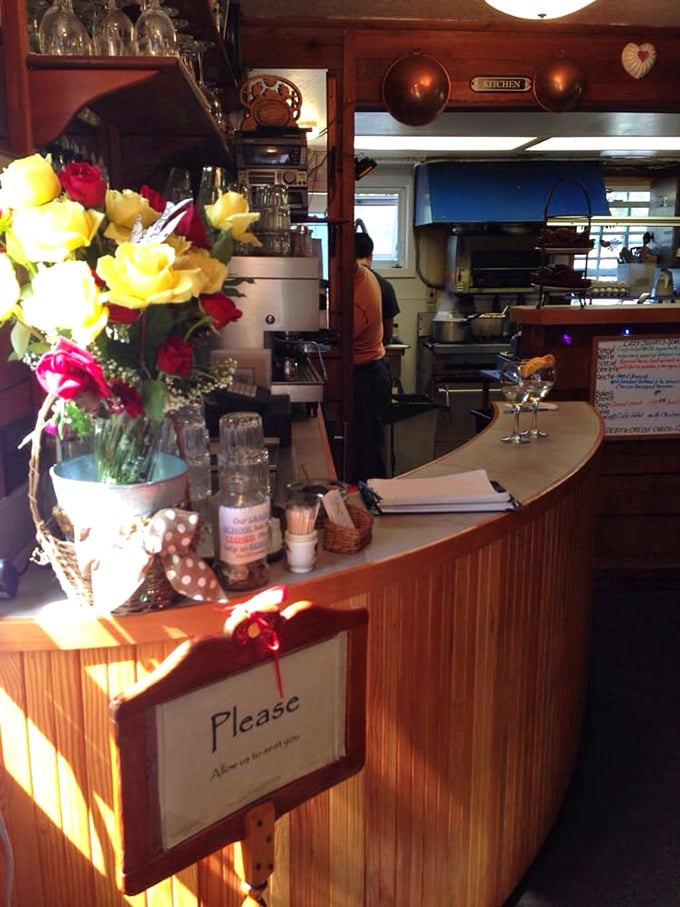 The heart of breakfast magic—a counter where fresh flowers meet efficiency, and every order gets the attention it deserves.