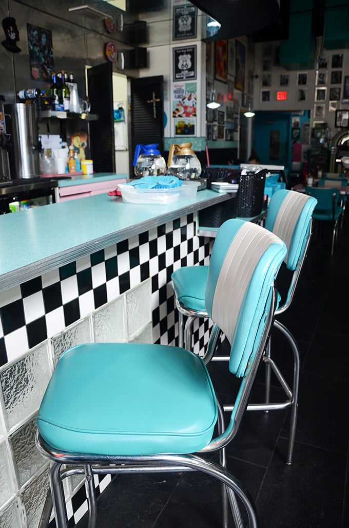 These aren't just counter stools—they're front-row seats to the greatest show on earth: breakfast theater, performed three times daily.