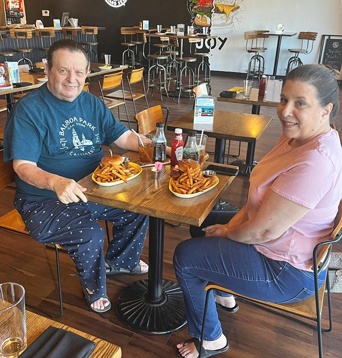 Happy diners proving that great food brings people together—nothing builds community quite like shared french fry appreciation.