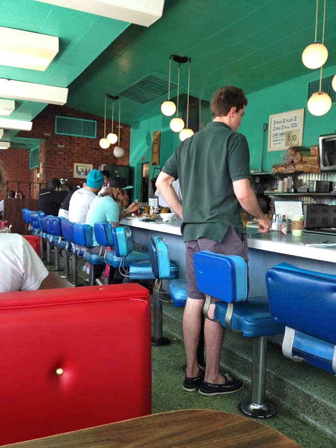 The blue counter stools aren't just seating—they're front-row tickets to the greatest show on earth: breakfast being made while you sip your coffee.