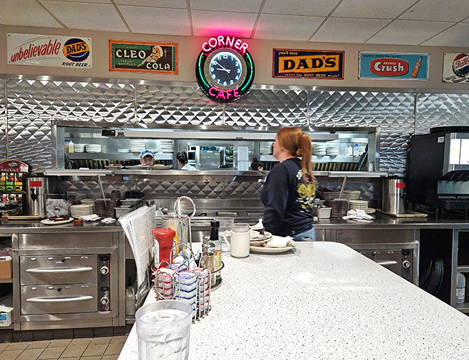 Behind the scenes where breakfast magic happens. The stainless steel kitchen gleams under vintage signs, a perfect blend of nostalgia and modern efficiency.