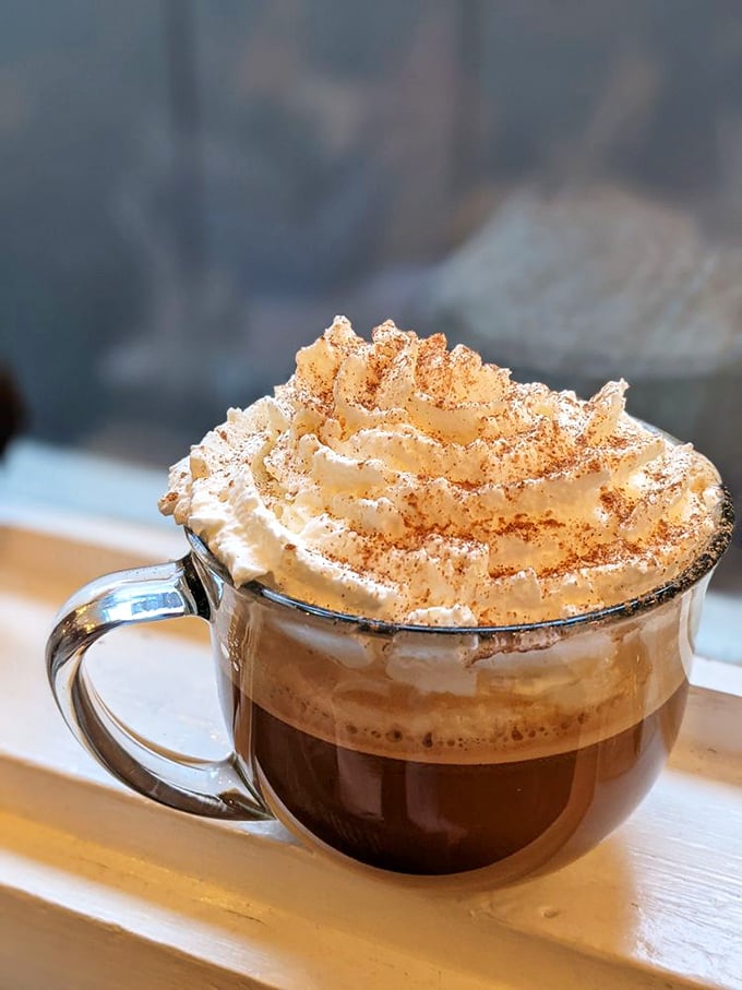 This isn't just coffee—it's a warm hug in a transparent mug, topped with cinnamon-dusted whipped cream that defies gravity and expectations.