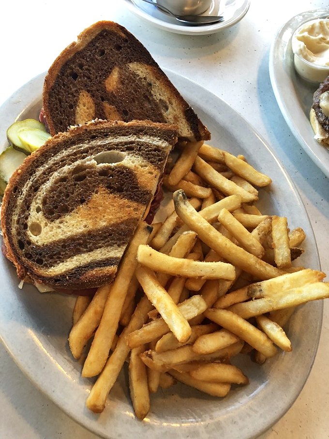 A Reuben sandwich that deserves its own parade. Those fries are playing the perfect supporting role in this lunch drama.