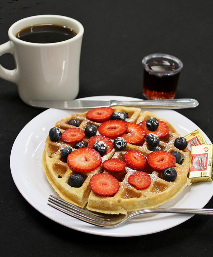 A Belgian waffle that's dressed for success with fresh berries and a light dusting of powdered sugar. Breakfast royalty.