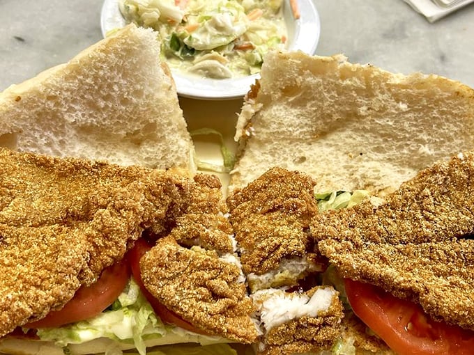 A sandwich that requires both hands and a strategy—golden-fried catfish nestled between bread that's just trying to keep up.
