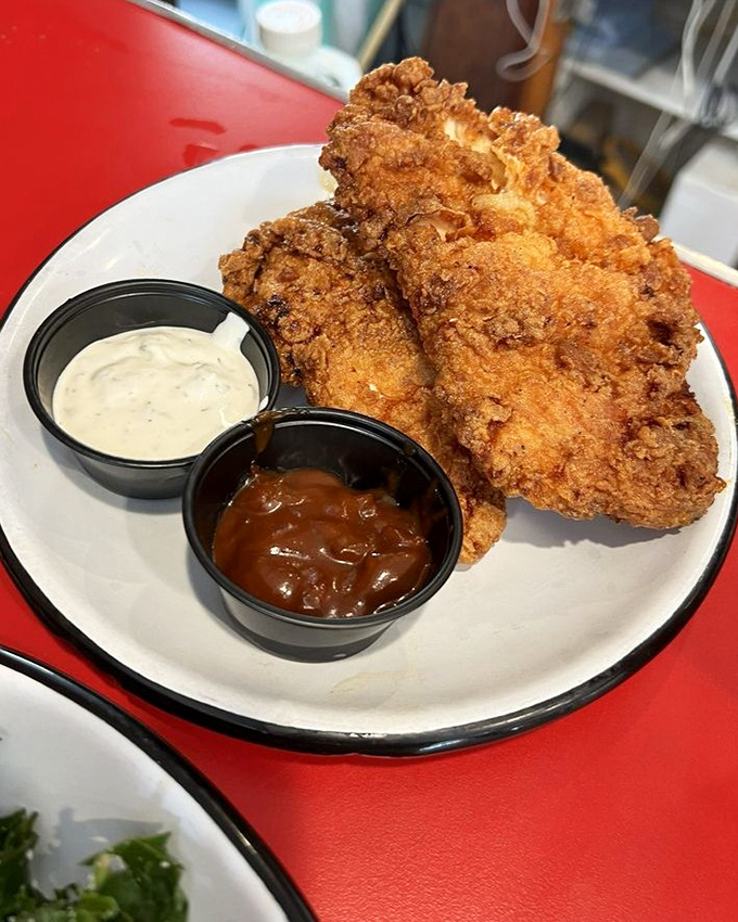 Fried chicken that's achieved the impossible trifecta – crispy exterior, juicy interior, and the power to make you forget your table manners.