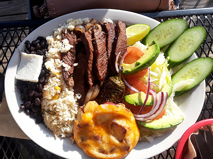 This plate doesn't just serve food—it serves a masterclass in balance with perfectly grilled steak, rice, beans, and fresh vegetables.