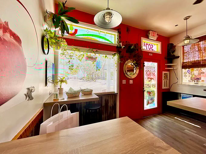 Plants that frame perfection. The interior's vibrant red walls and stained glass window create a shrine to the humble lobster roll.