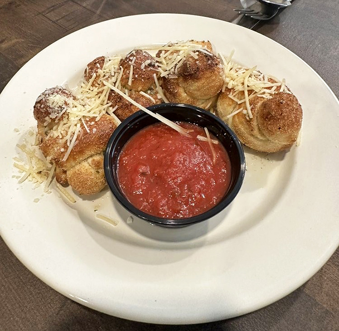 Garlic knots dusted with Parmesan and served with marinara—simple pleasures that make you question why bread needs to be any more complicated than this.