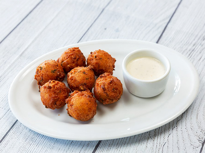 These hush puppies aren't staying quiet about how delicious they are—golden-fried cornmeal fritters with a pillowy interior that demands attention.