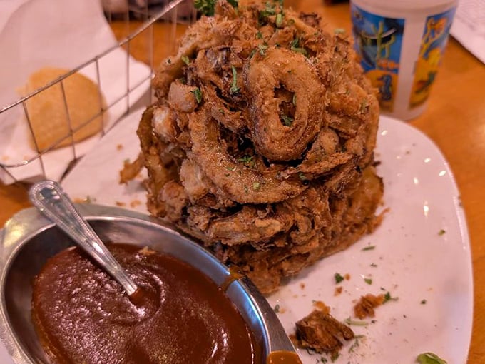 The Onion Brick—architecture meets appetite in a towering achievement of crispy, golden rings. Dipping sauce stands ready for its supporting role in this crunchy drama.