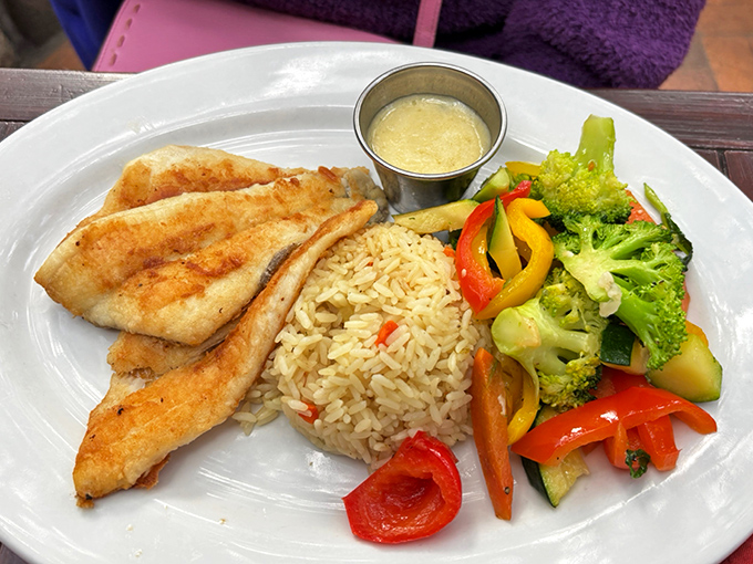 This delicate white fish arrives like a painting on a plate—crisp vegetables and fragrant rice playing supporting roles to the perfectly seared star.