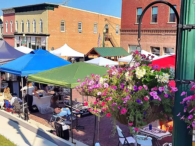 The farmers market transforms brick streets into a canvas of color—where conversations flow as freely as the coffee at the corner café.