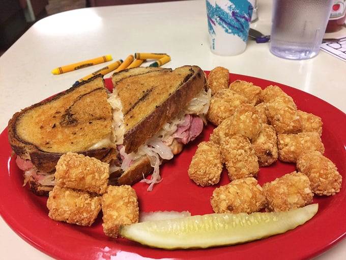 A Reuben sandwich that's been working out—thick, proud, and accompanied by tater tots that refused to grow up into full potatoes.
