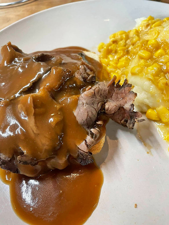Roast beef swimming in gravy alongside creamed corn—a plate that whispers "take a nap afterward" with every savory, comforting bite.
