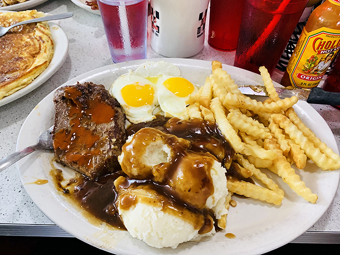 This isn't just a meal, it's a commitment – steak, eggs, mashed potatoes, and gravy creating the ultimate "I'm not hungry until dinner" experience.