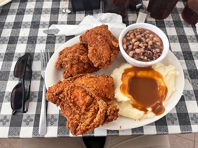 Fried chicken with the golden ratio of crunch to juiciness, alongside black-eyed peas and mashed potatoes swimming in gravy.