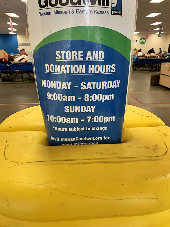 The hours of operation sign perched atop a yellow cushion—essential information for planning your next bargain expedition.