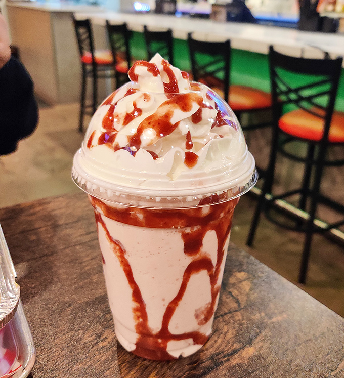 Strawberry shake art that belongs in both galleries and stomachs. The swirls of sauce create a dessert that's almost too pretty to drink—almost.