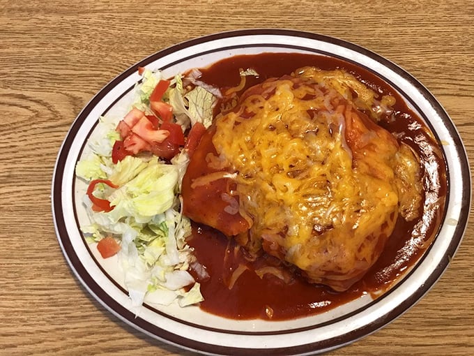 Red chile sauce transforming an ordinary stuffed sopapilla into an extraordinary experience—this is New Mexico's edible heritage on a plate.