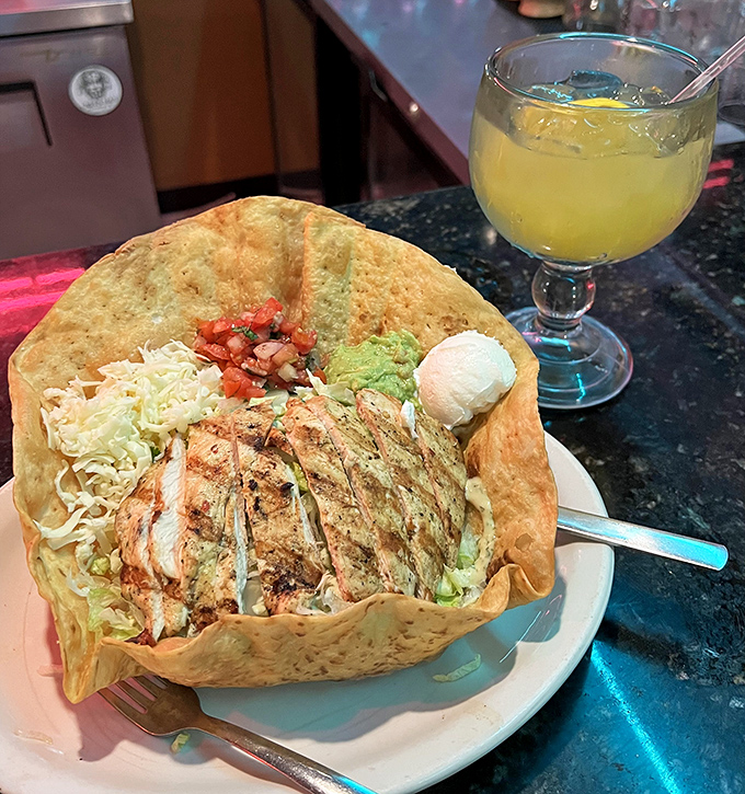 A taco salad served in a crispy shell bowl with a margarita sidekick—lunch of champions or dinner of dreams?
