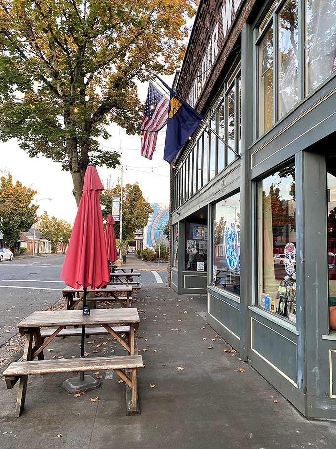 Those wooden picnic tables outside The Axe and Fiddle aren't just seating—they're front-row tickets to the parade of small-town life passing by.