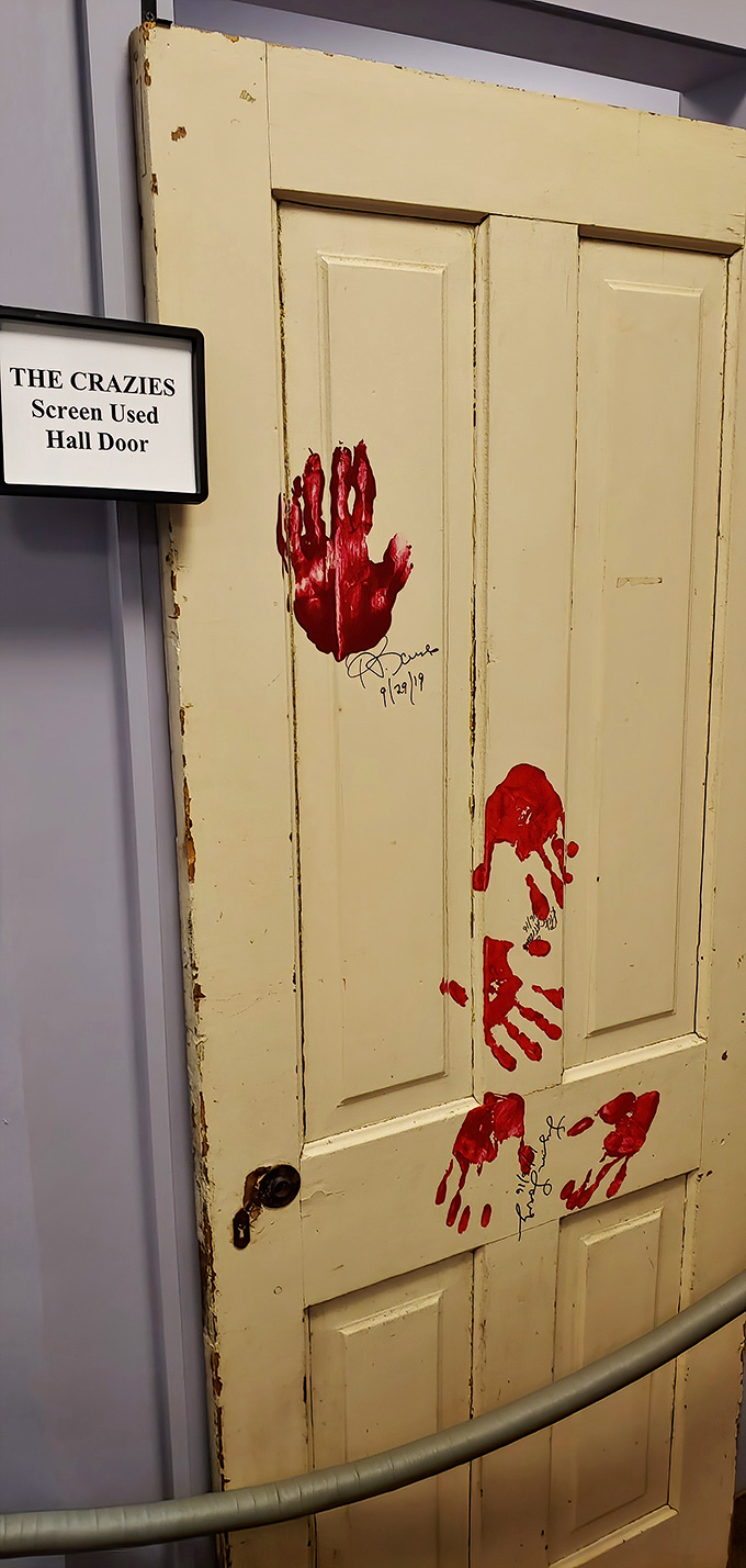 Blood-smeared handprints tell a desperate story on this screen-used door—some movie props are worth preserving for posterity.